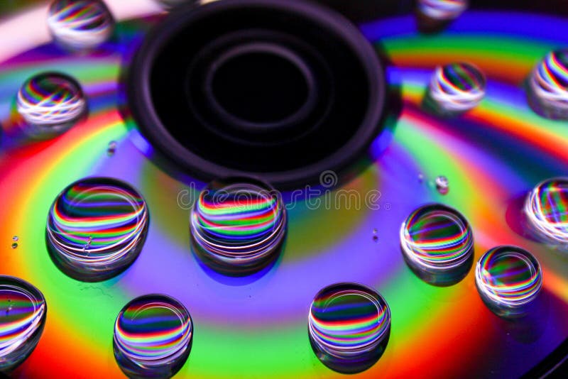 Closeup of a Compact Disc with Rainbow Color Reflection and Water Drops ...