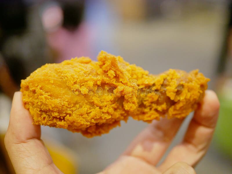 Closeup of Crispy Golden Fried Chicken in a Hand Ready To Be Eatten ...