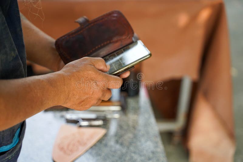 Closeup and Crop Leathers Maker Using Smart Mobile To Check an Orders ...