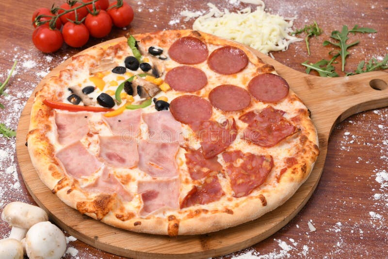 Closeup of a Delicious Pizza Divided into Four Parts with Different ...