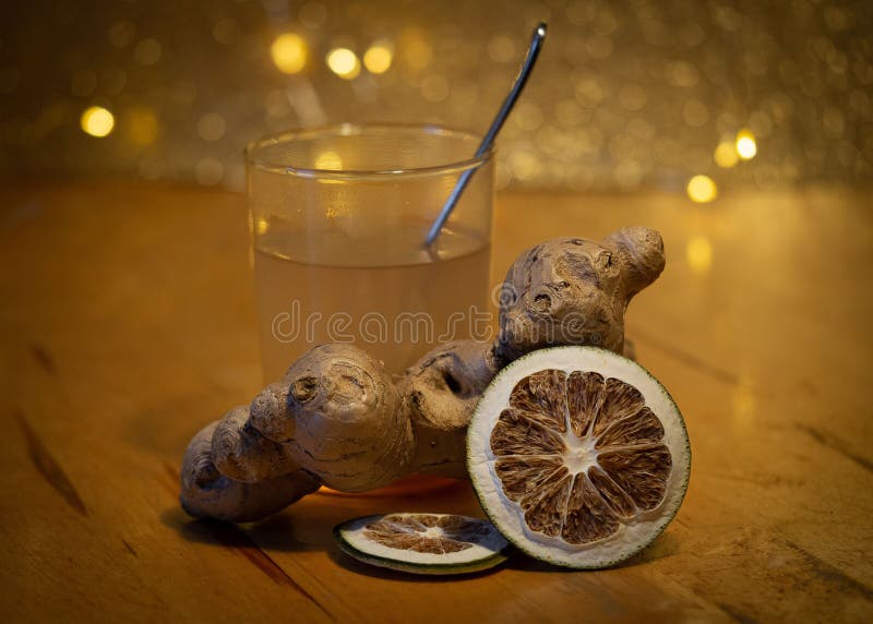 Closeup of a Dring in a Glass Cup Next To Ginger and a Slice of Dried ...