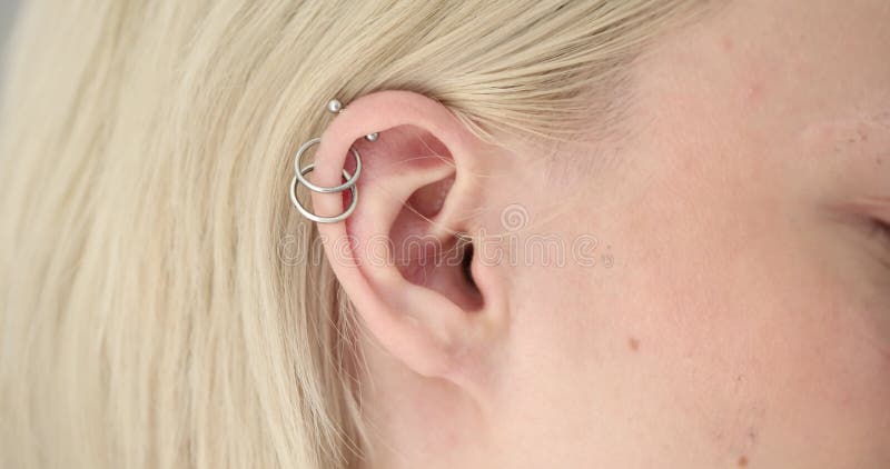 Closeup of Ear Piercing with Two Rings on Upper Ear Stock Video - Video ...