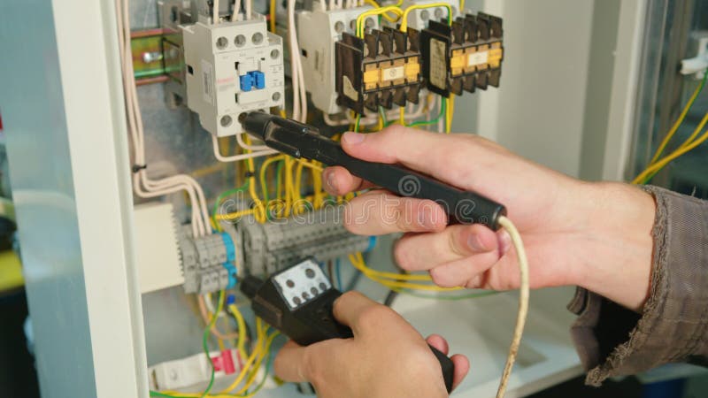 Electricians Hands Testing Current Electric in Control Panel ...