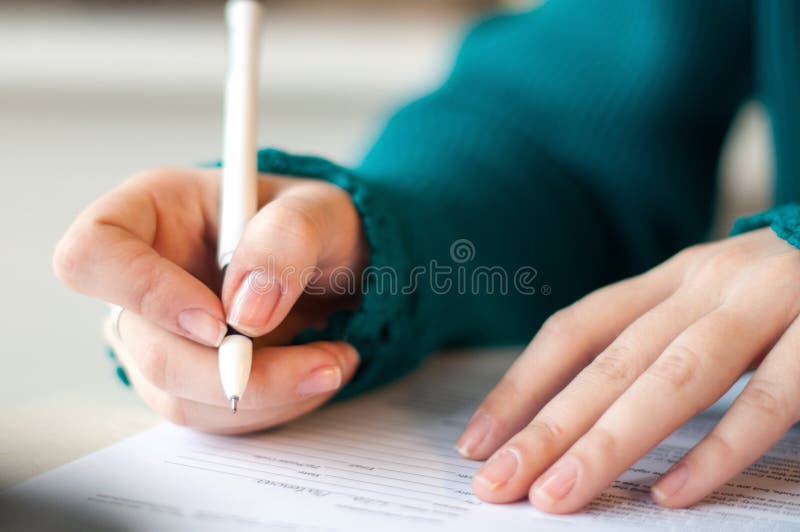 Closeup of Female Hands Signing Document in Blue Sweater with Black Pen ...