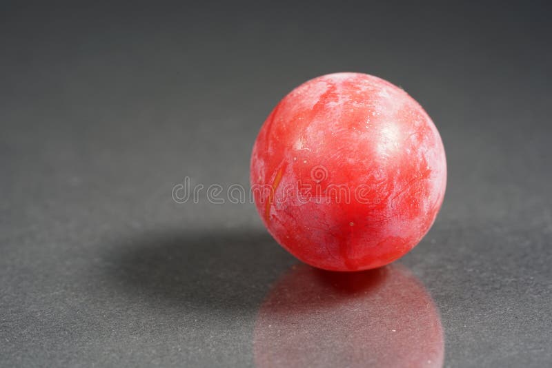 Closeup Focus Shot of a Small Red Ball on a Reflective Surface Stock ...