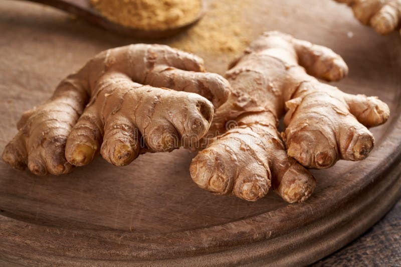 Closeup of Fresh Ginger Root with Ground Ginger in the Background Stock ...