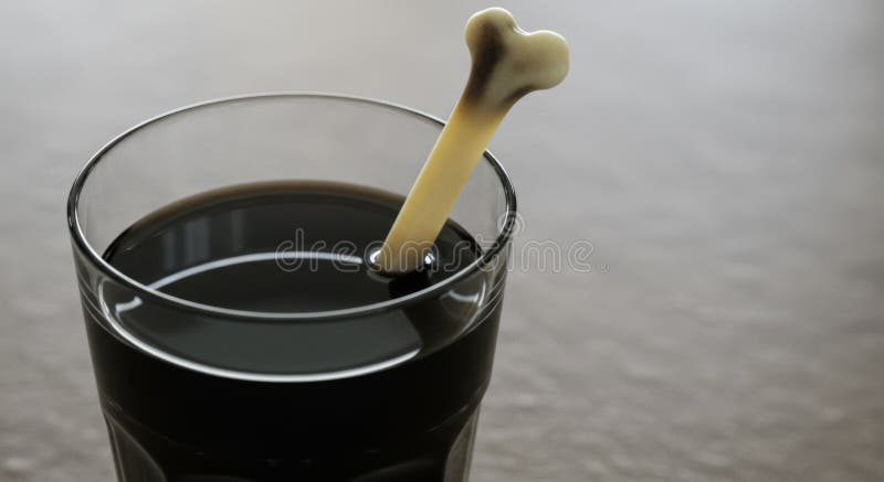 Closeup of a Glass of Dark Liquid with a Small Bone Stock Photo - Image ...