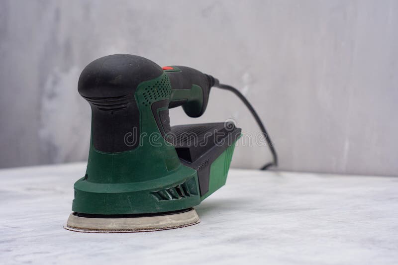 Closeup of Green Electric Orbital Sander on Marble Surface with Sanding ...