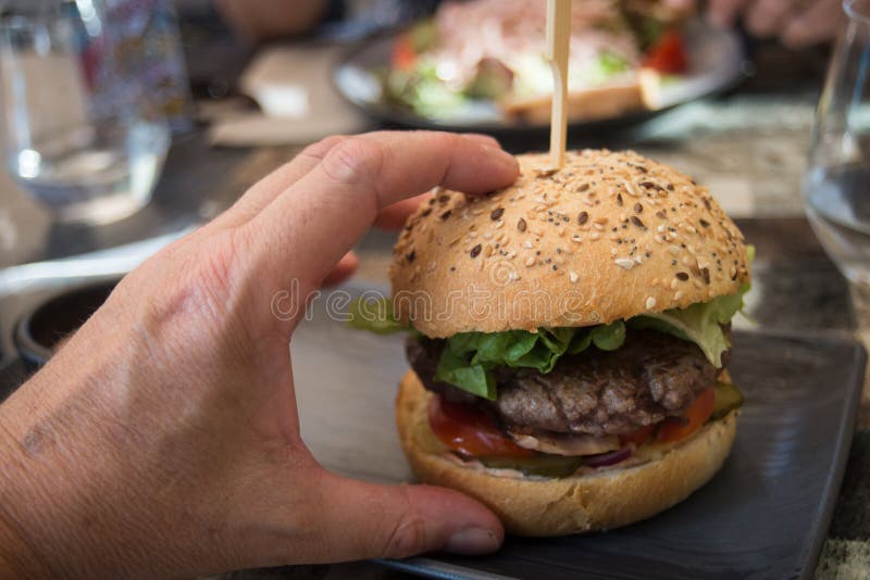 Hamburger in Hand at the Restaurant Terrace Stock Image - Image of meat ...