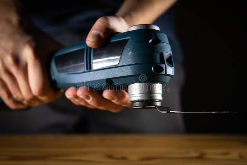 CloseUp of a Hand Gripping a Power Multi Cutter Tool Equipped with a ...