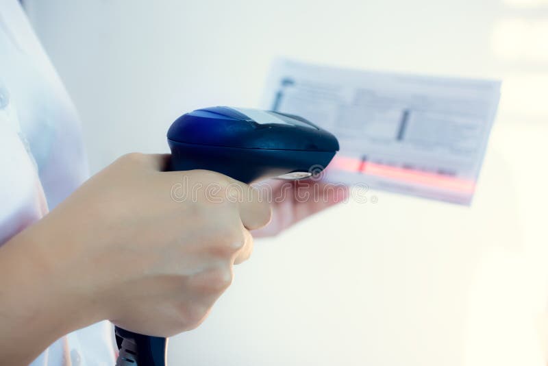 Closeup of Hand Holding Bar Code Scanner and Scanning Code on Invoice ...