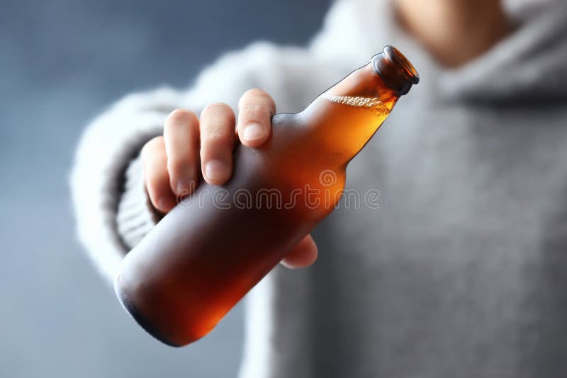 Closeup of a Hand Holding a Bottle of Amber Liquid, Suggesting ...