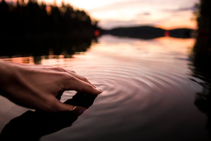 Closeup of a Hand Touching the Water Making Smooth Waves on the Surface ...
