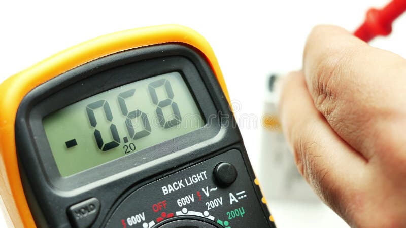 Closeup Hand Using Digital Multimeter To Measure Level of Charge of a ...