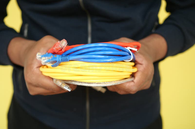 A Closeup of Hands Holding a Coiled Blue Ethernet Cable for a Network ...