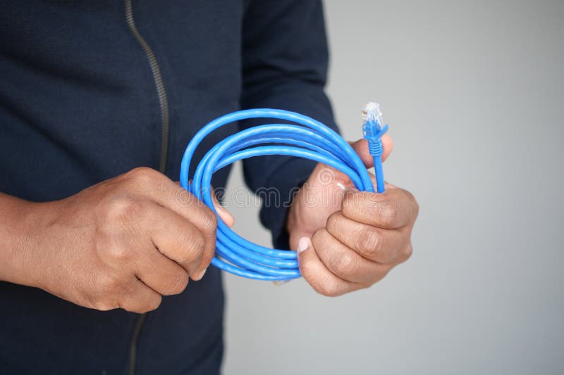 A Closeup of Hands Holding a Coiled Blue Ethernet Cable for a Network ...