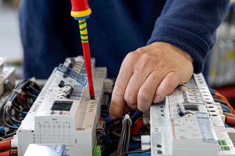Closeup of the Hands Holding a while Working on the Electrical ...