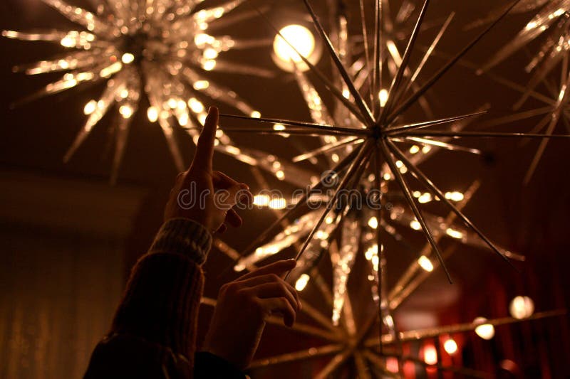 Closeup of Hands Touching a Decorative Spiky Star Hanging from the ...