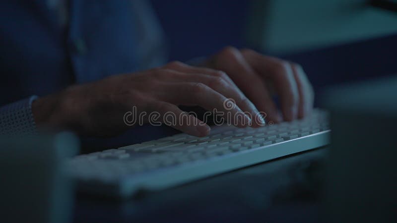 Focused Hands Skillfully Typing on a Keyboard while in a Dark and ...