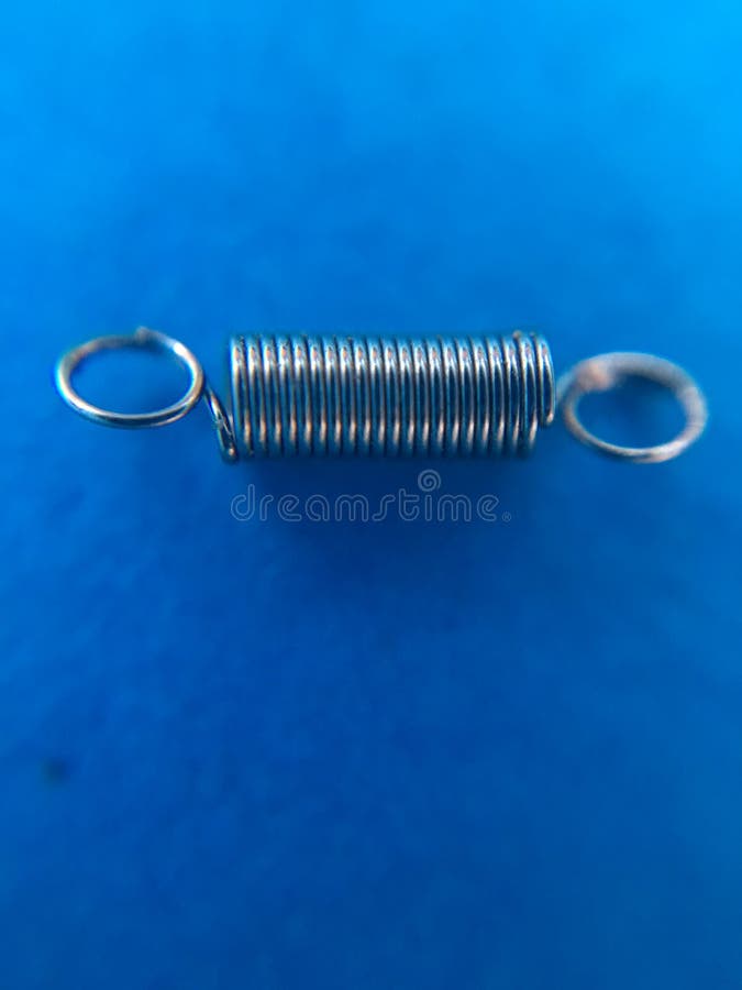 Closeup of a Helical Spring Placed on a Blue Color Paper Stock Photo ...