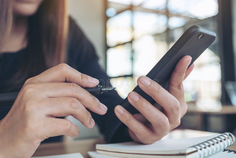 A Woman Holding , Using and Looking at Smart Phone while Working in ...