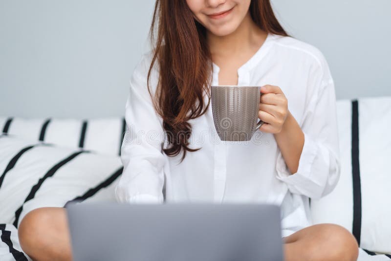 A Beautiful Woman Using And Working On Laptop Computer Drinking