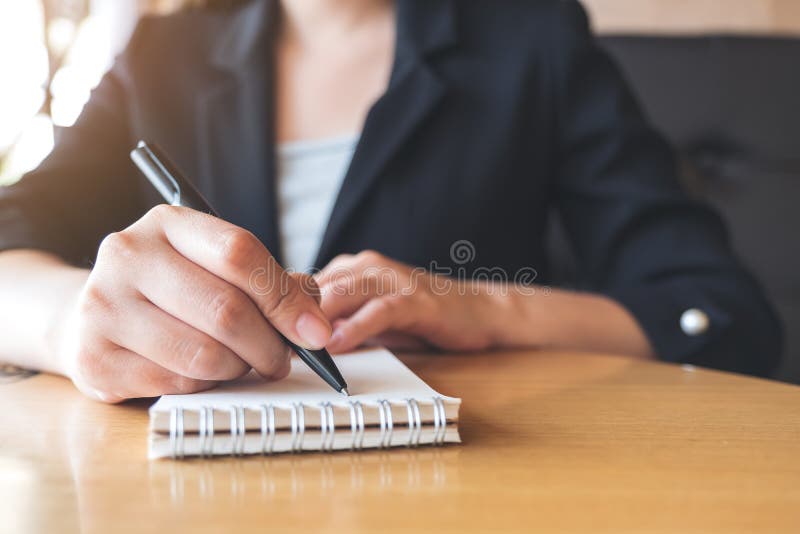 A Business Woman Writing Down on a White Blank Notebook on Table in ...