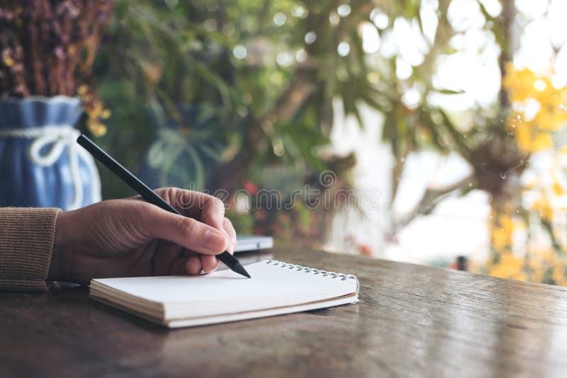 Hand Writing Down on a Blank Notebook on Wooden Table Stock Photo ...