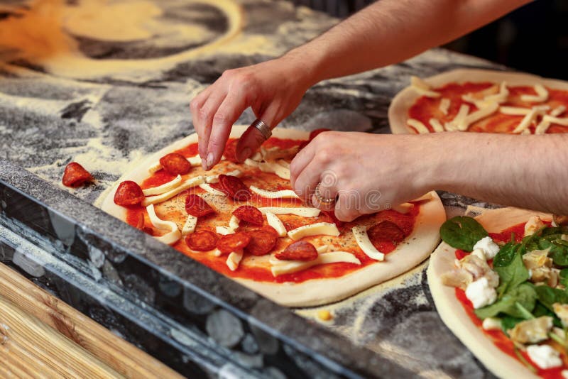 Closeup Image of Pizzamaker Spreading Pepperoni on Pizza Dough Stock ...