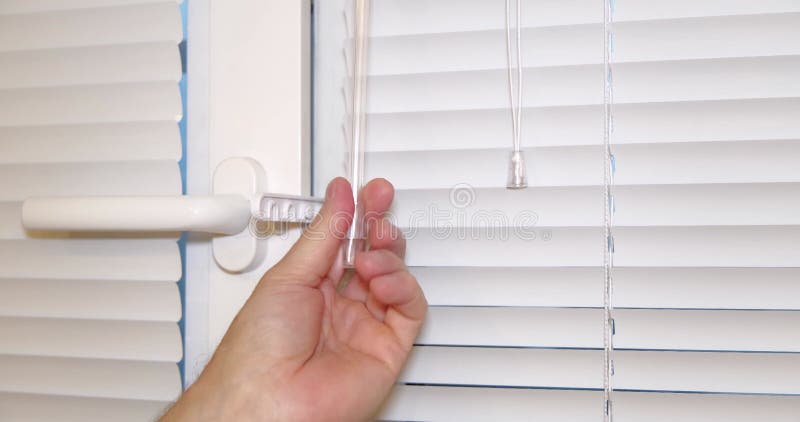 A Closeup Image Showcasing a Hand Skillfully Adjusting a Window Blind ...
