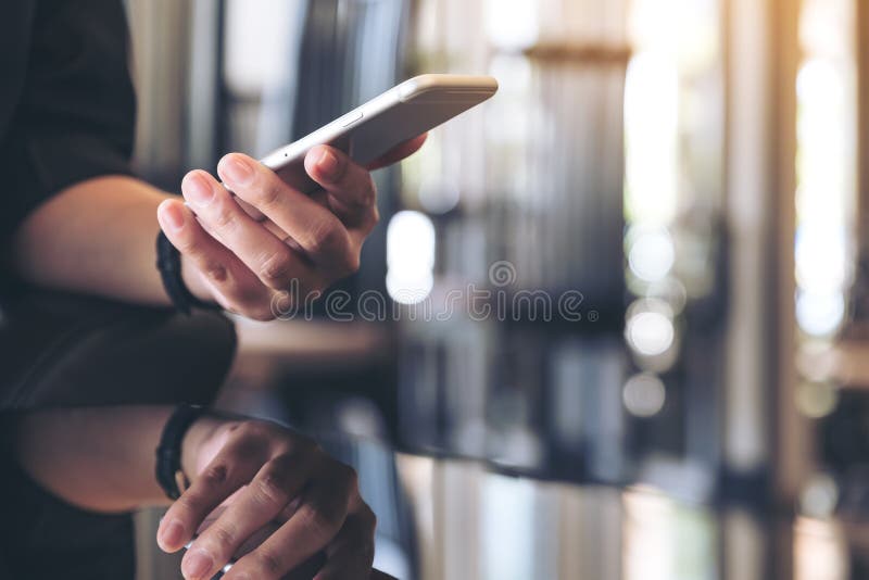 A Woman Holding and Using Smartphone with Reflection on Grass Table in ...
