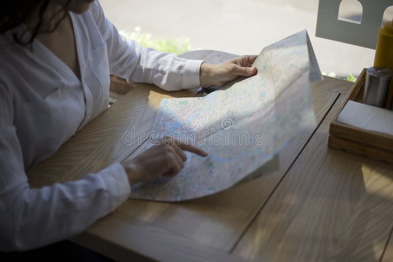 Closeup Image of Women`s Hand Pointing on a Map, Seated at the Table in ...