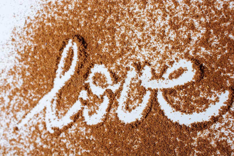 Closeup of [love] Written with Brown Powder on a White Surface Under ...