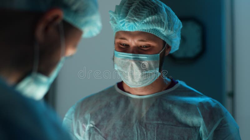 Closeup of Male Surgeon and Intern Holding Friendly Conversation during ...