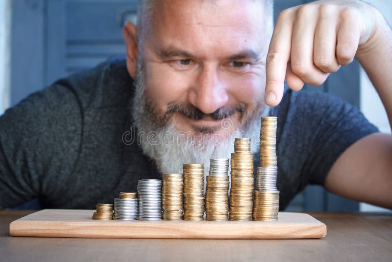 Close-up Man Collects Columns of Multi-colored Coins of Increasing ...