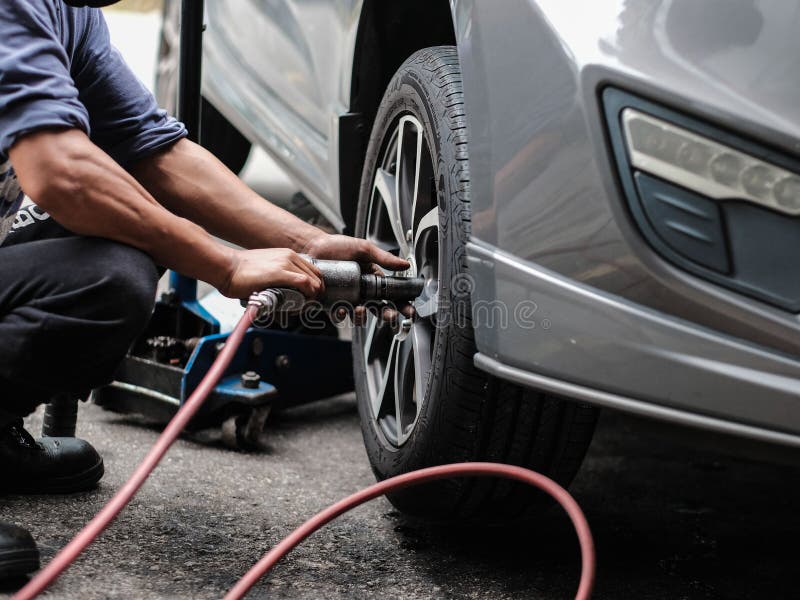 Closeup of a Man Fixing His Car Tire with a Tool Stock Image - Image of ...