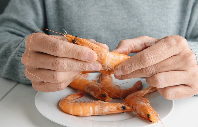 Closeup of a Man Removing the Head of a Prawn Stock Photo - Image of ...