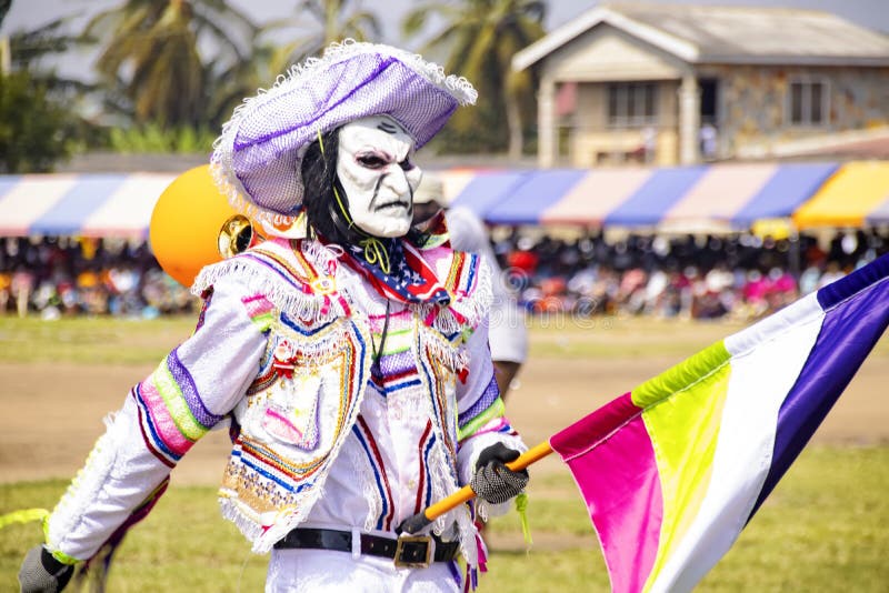 Closeup of a Masquerade Performer Marching with a Flag in Hand ...