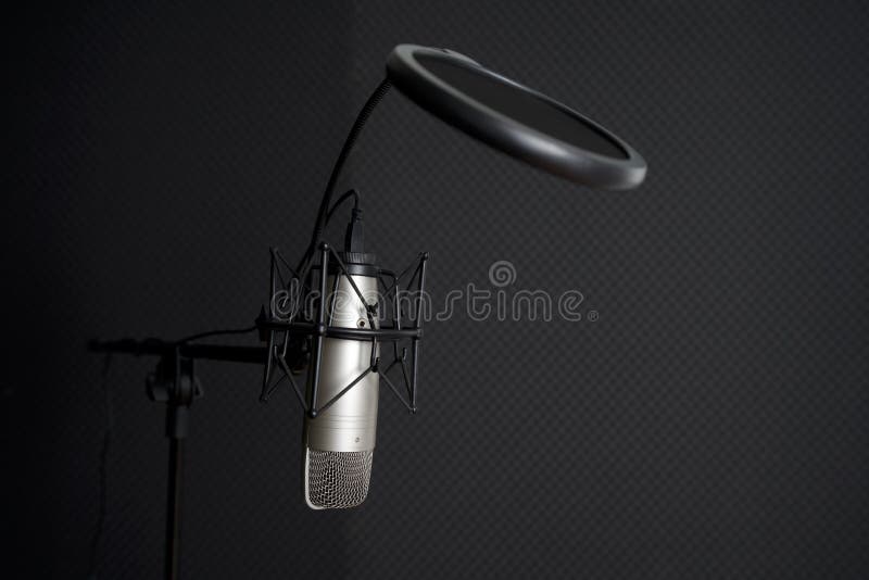Closeup Microphone on a Stand in Front of Black Soundproof Wall in ...