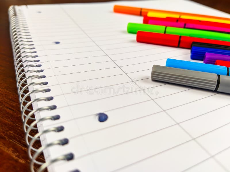 Closeup of Notebook Spiral and Colorful Pens Laying on an Empty White ...
