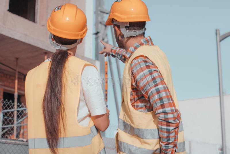 Closeup of a Pair of Builders Pointing at the Construction Site Stock ...