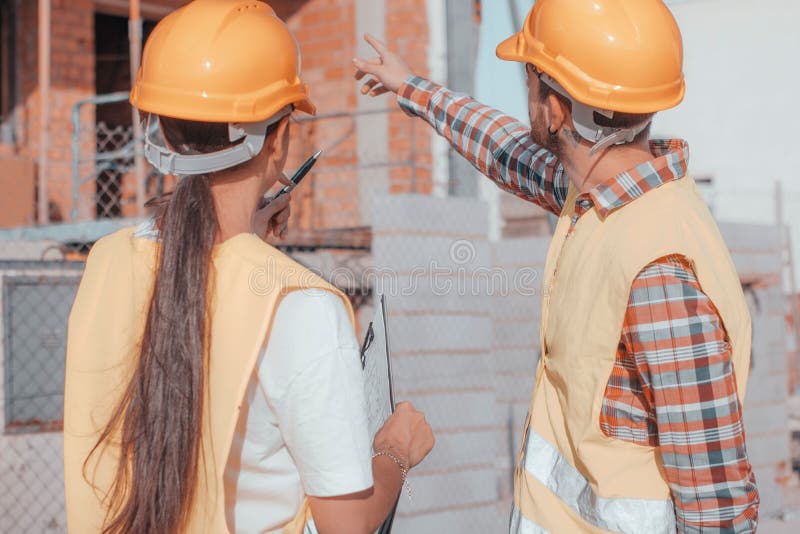 Closeup of a Pair of Builders Pointing at the Construction Site Stock ...