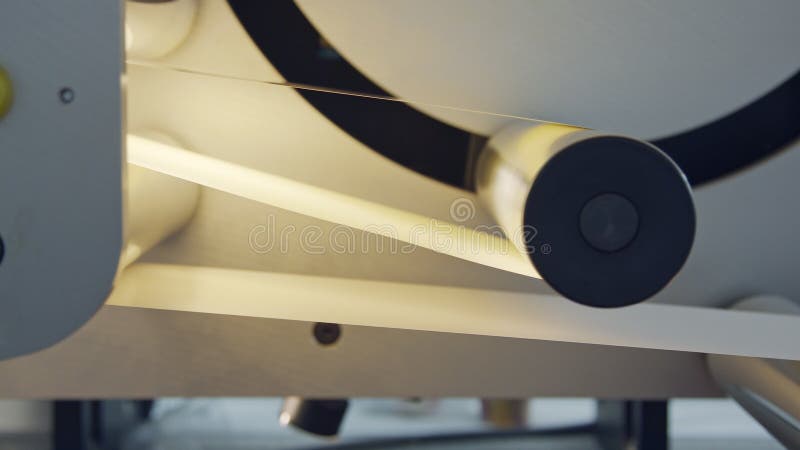 Closeup on Paper Moving through a Large Industrial Printing Machine ...