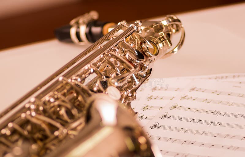 Closeup Partly View of Shiny Saxophone Lying on Musical Notes Paper ...