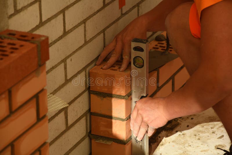 Closeup of a Person Laying Bricks and Taking Measurements in a ...