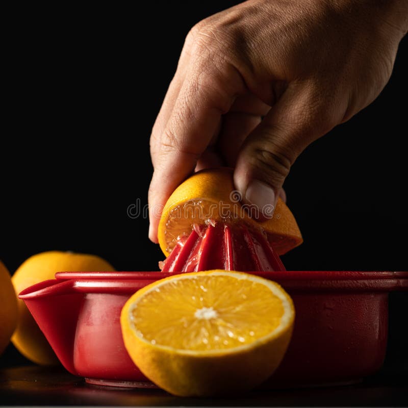 Closeup of a Person Squeezing Lemon on a Red Strainer Under the Lights ...