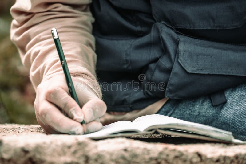 Closeup of a Person Taking Notes in a Notebook while Wearing Industrial ...