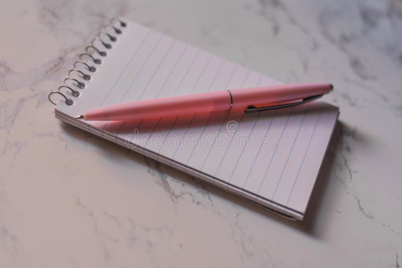 Closeup of a Pink Pen on a Block Note on the Table Under the Lights ...