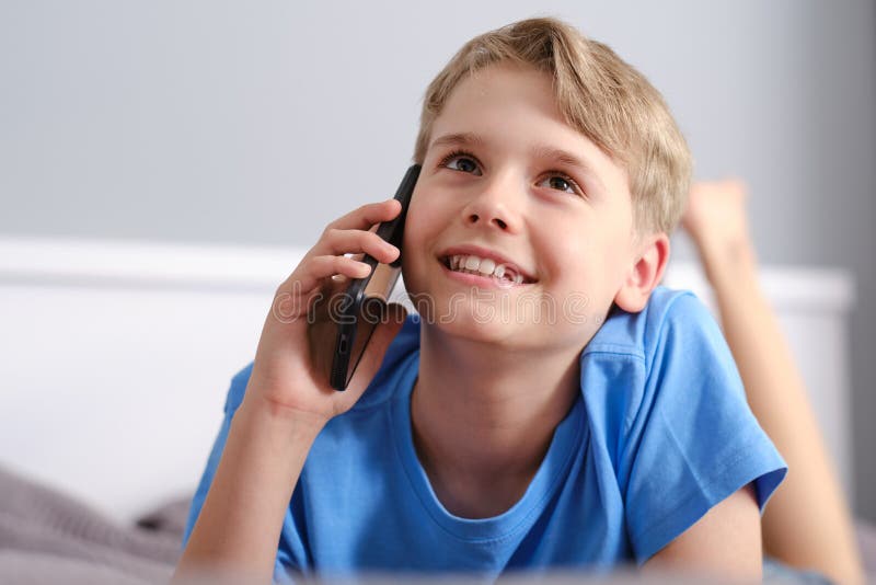 Closeup Portrait of a Cute Boy Talking on the Phone while Lying on the ...
