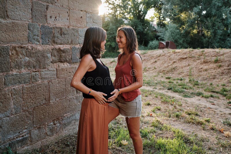 Closeup Of A Pregnant Lesbian Couple Doing A Photoshoot In A Park Stock